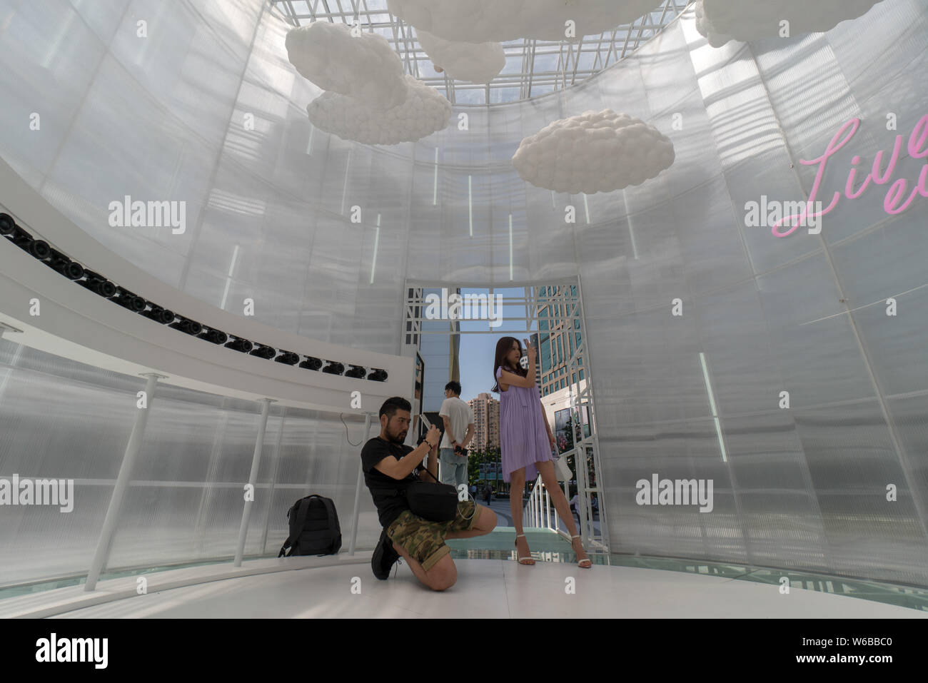 Tourists enjoy themselves in a white cube installation with 22 SLR ...