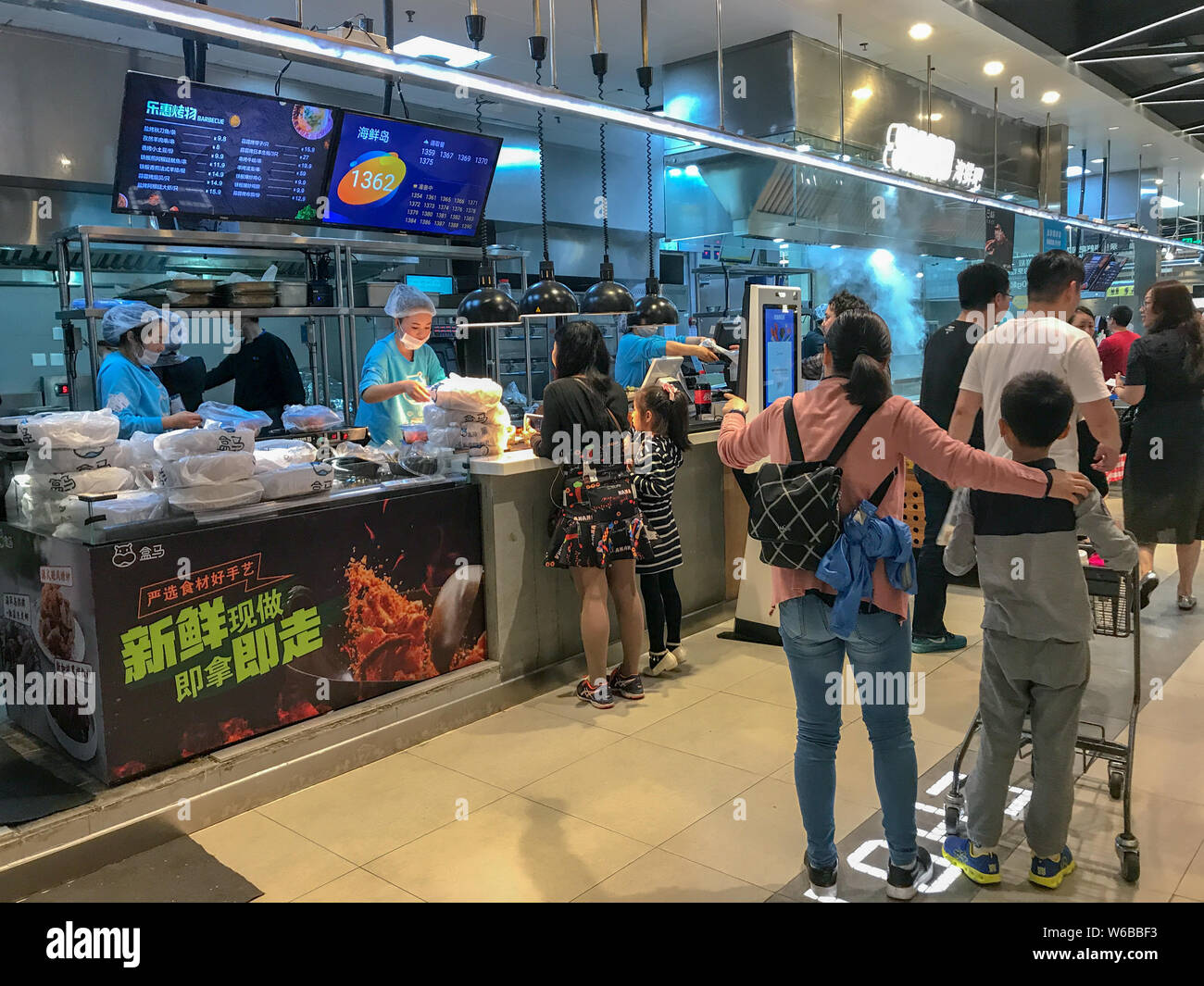 Customers shop at the fresh food e-commerce experience store ...