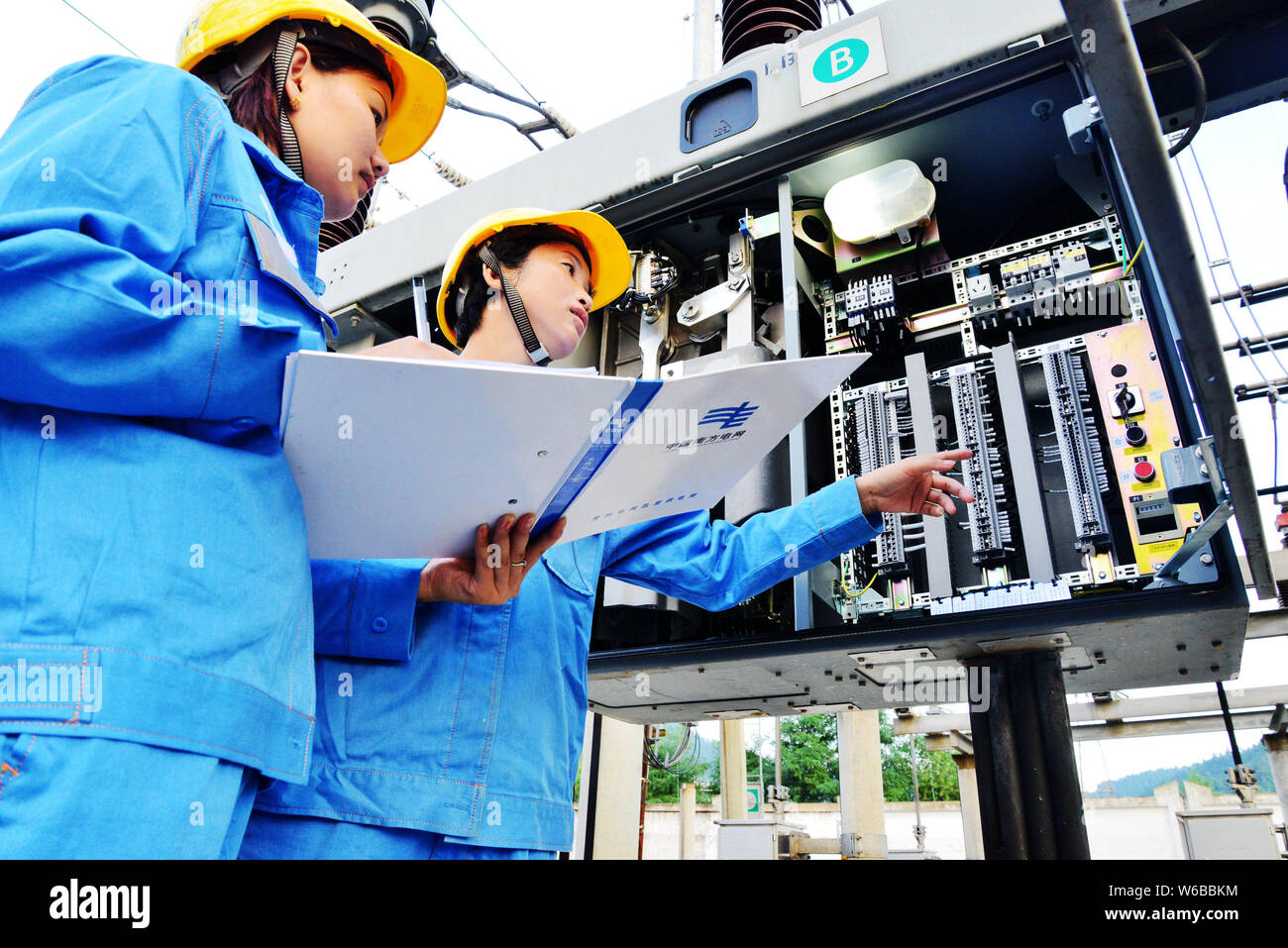 --FILE--Female Chinese workers of China Southern Power Grid check ...