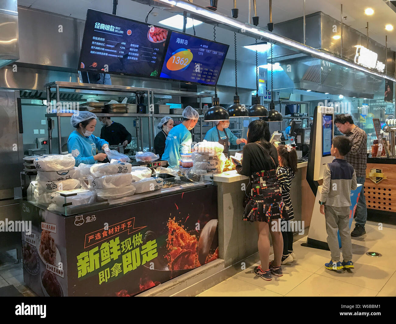 Customers shop at the fresh food e-commerce experience store ...