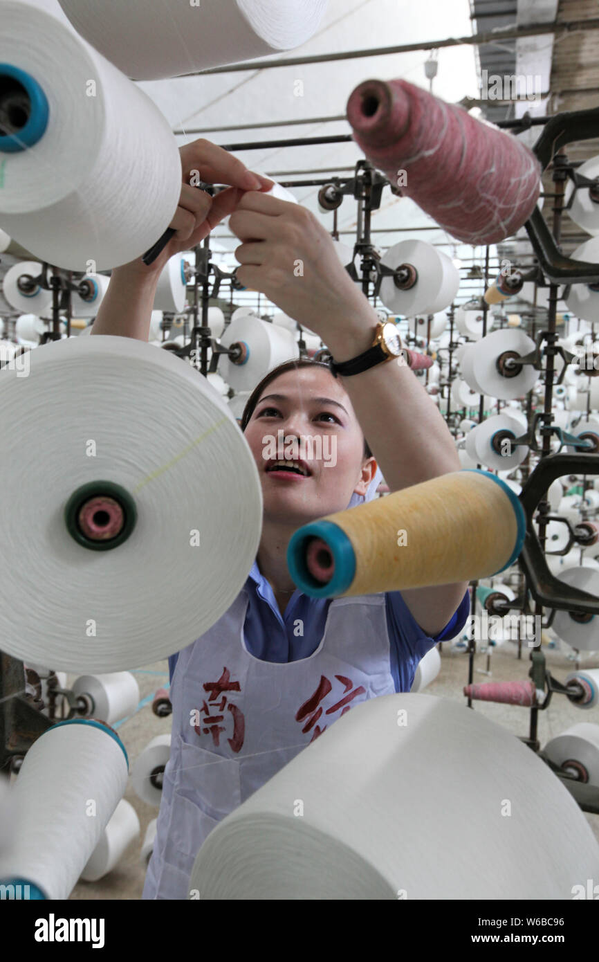 --FILE--A female Chinese worker handles production of yarn at a textile factory in Nanping city ...