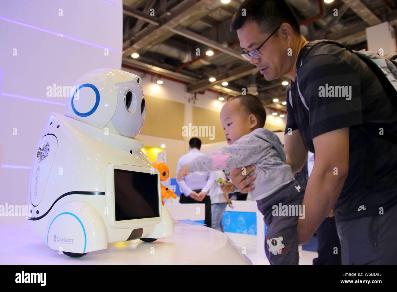 A child interacts with a robot that can accompany children during the ...