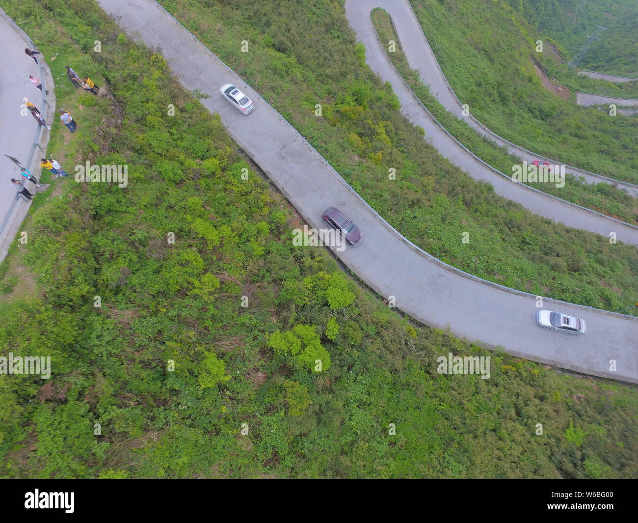 Cars drive on a section of winding road with 45 curves linking Xiushan ...