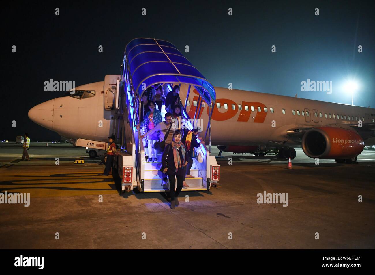 First group of Indonesian tourists deplane as they arrive at the Haikou ...