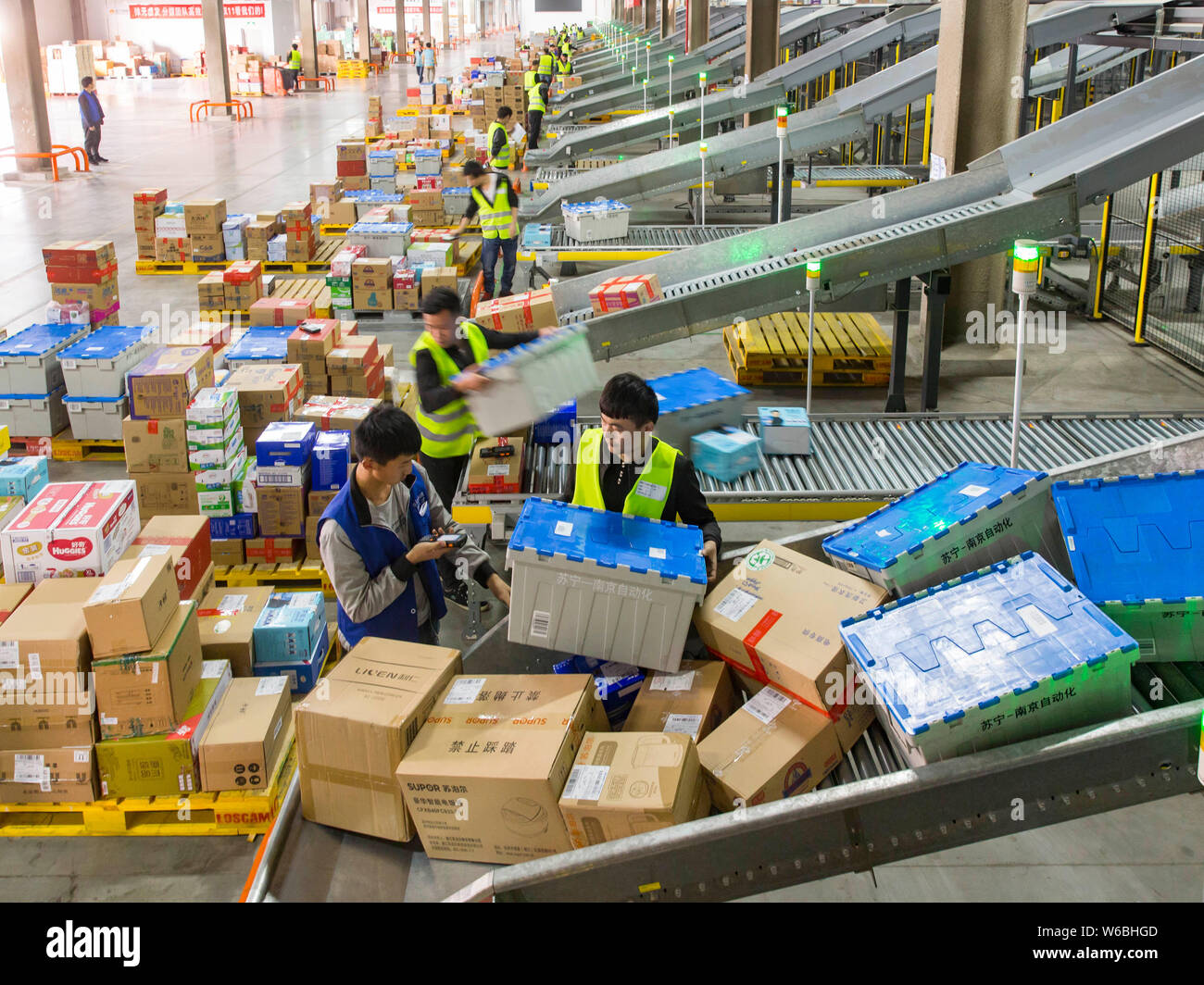 --FILE--Chinese workers sort piles of parcels at the smart warehouse of ...