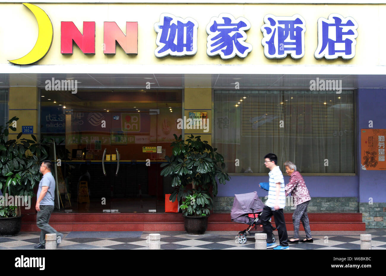 --FILE--Pedestrians walk past a branch of Home Inn in Xiamen city ...
