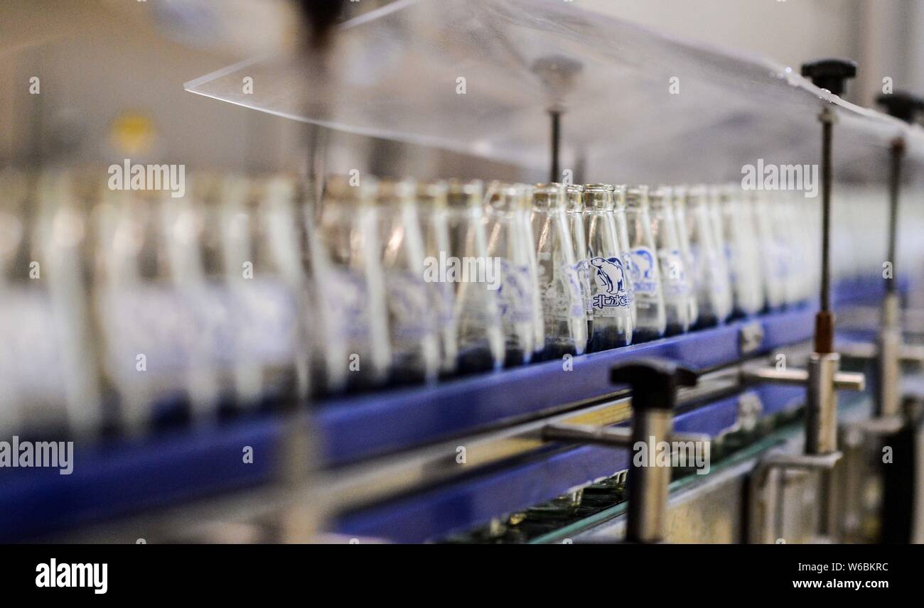 Bottles are to be filled with orange soda after being cleaned and ...