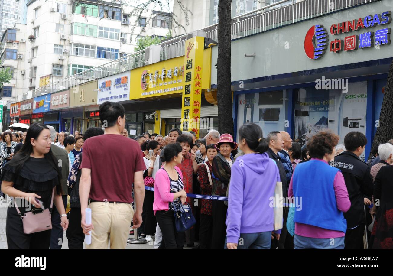 Local Chinese residents queue up in front of a branch of China Gas to ...