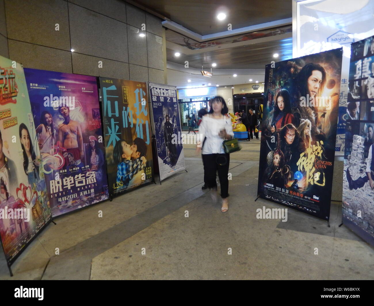 --FILE--Chinese moviegoers walks past posters for films at a cinema in ...