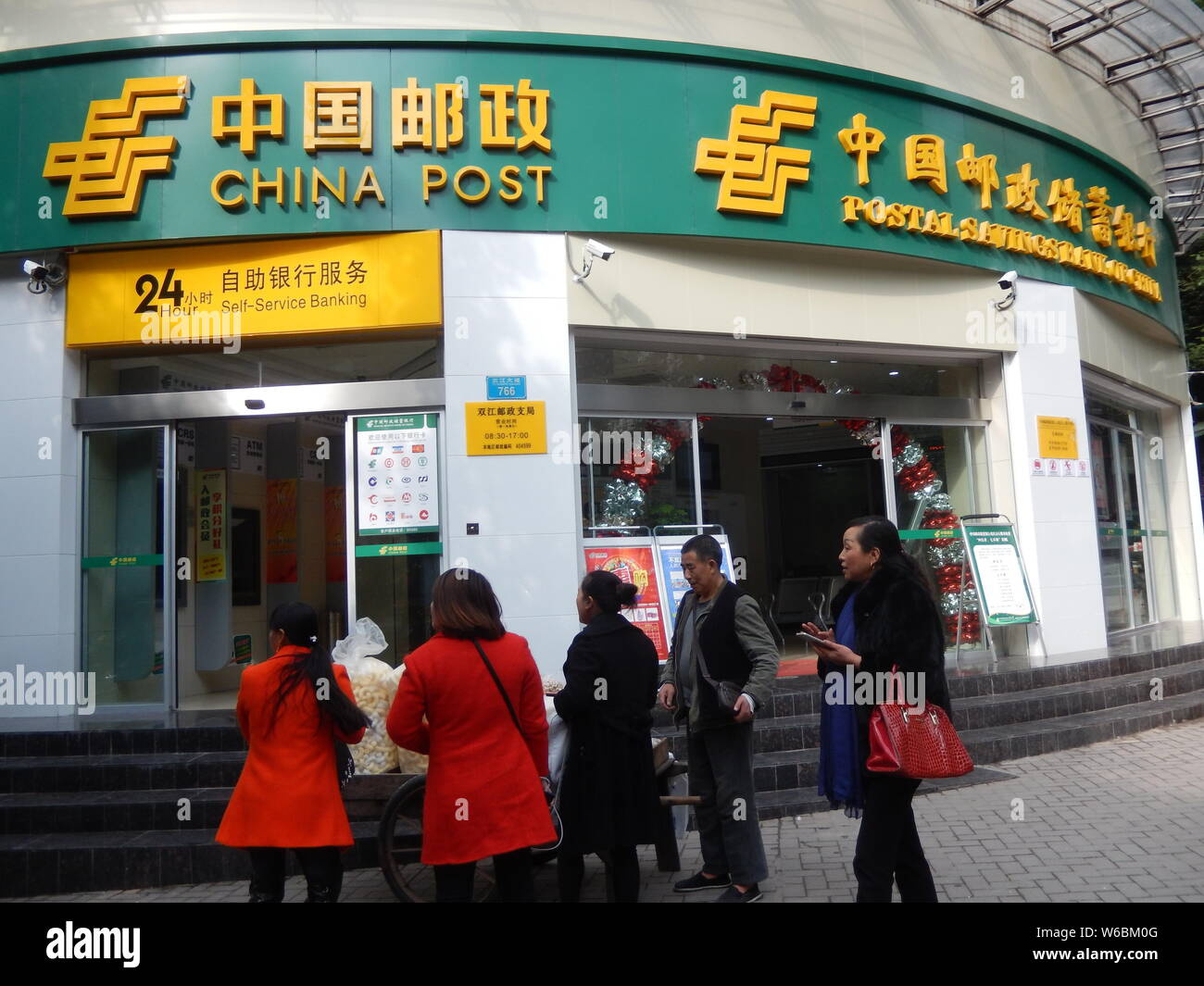 --FILE--Pedestrians walk past a branch of China Post and Postal Savings ...