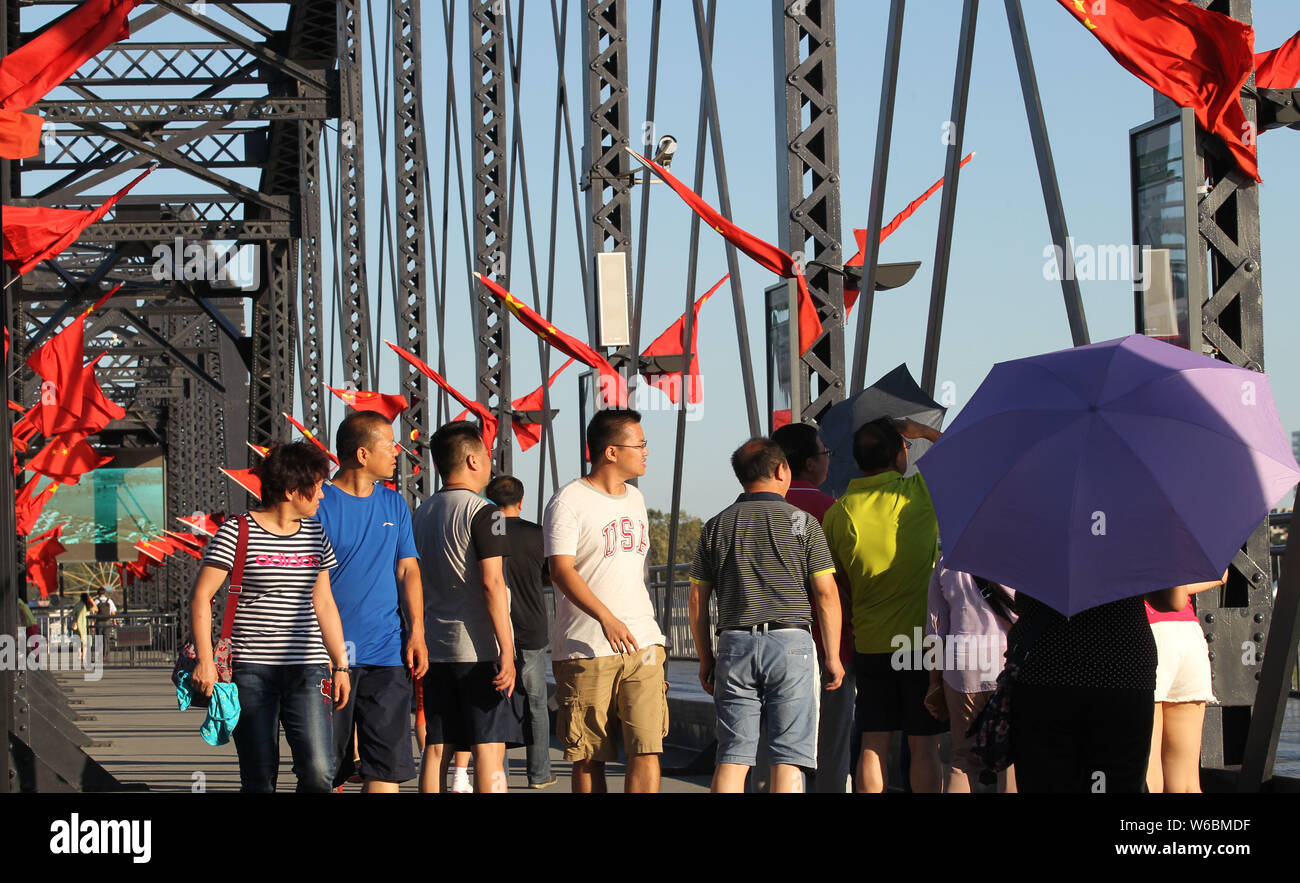 Tourists walk on the Yalu River Broken Bridge over the Yalu River, also ...