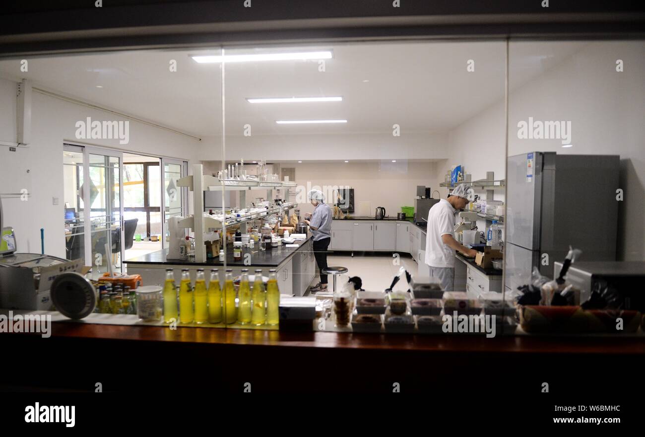 Chinese workers check the production of Beibingyang orange soda on the ...