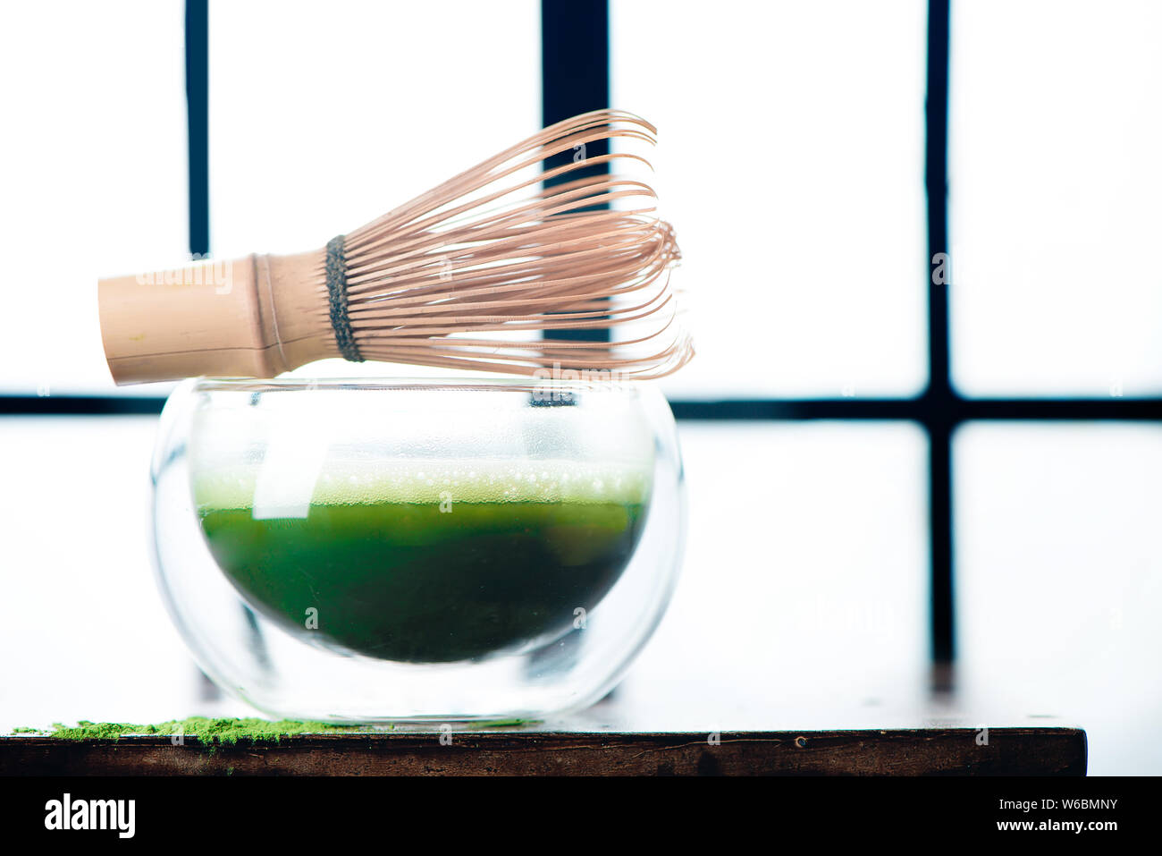 Matcha green tea close-up with a double wall glass tea bowl and a ...