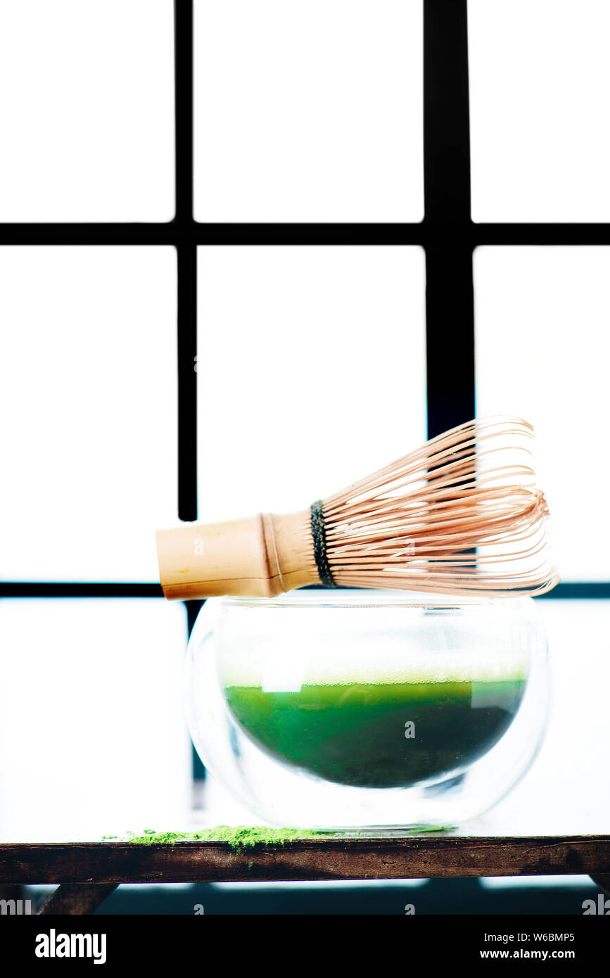 Matcha green tea close-up with a double wall glass tea bowl and a ...