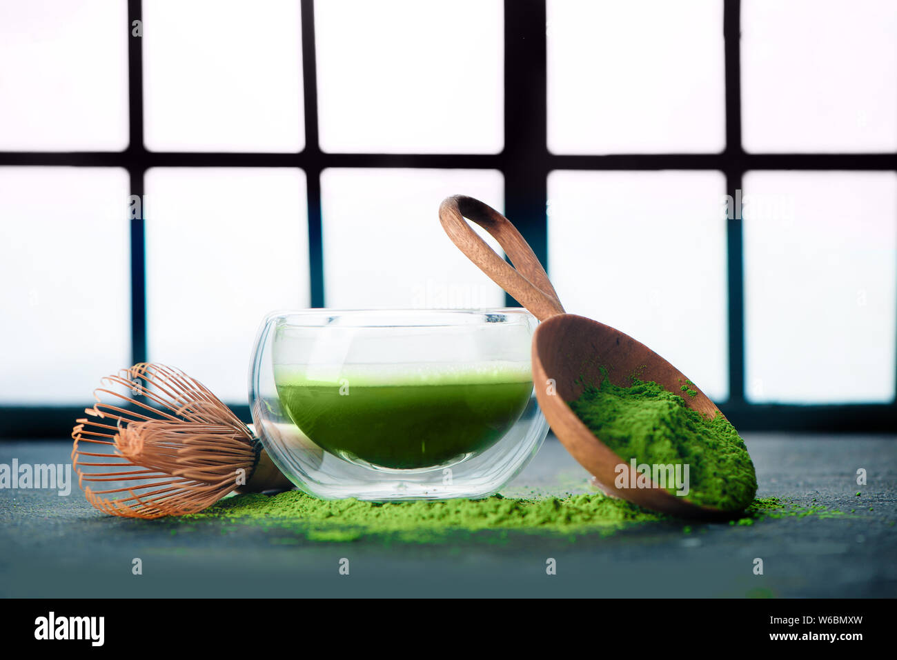 Matcha green tea close-up with a double wall glass tea bowl and a ...