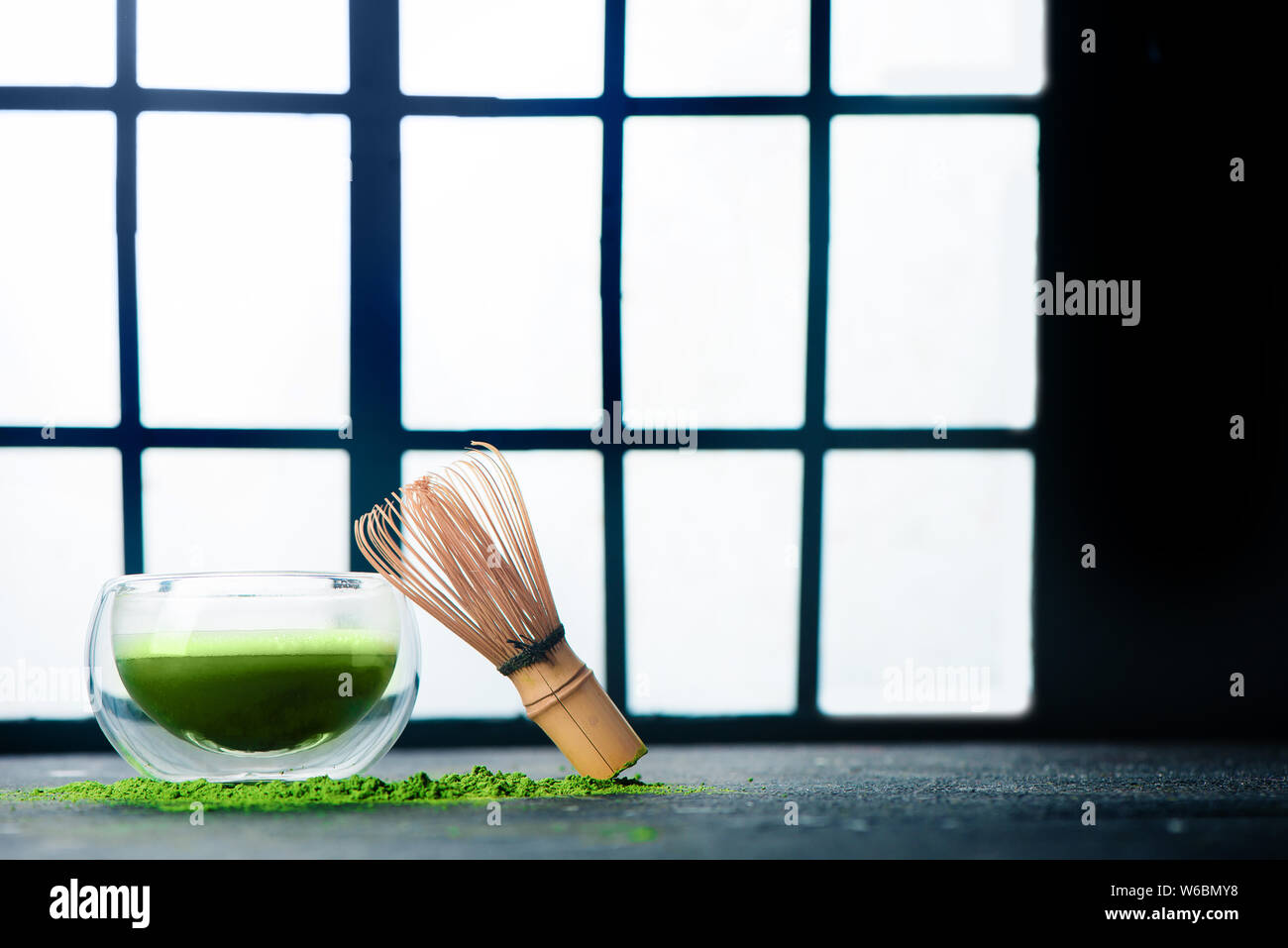 Matcha green tea close-up with a double wall glass tea bowl and a ...