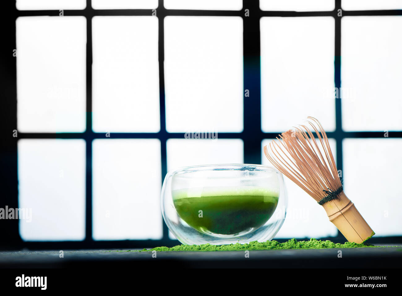 Matcha green tea close-up with a double wall glass tea bowl and a ...