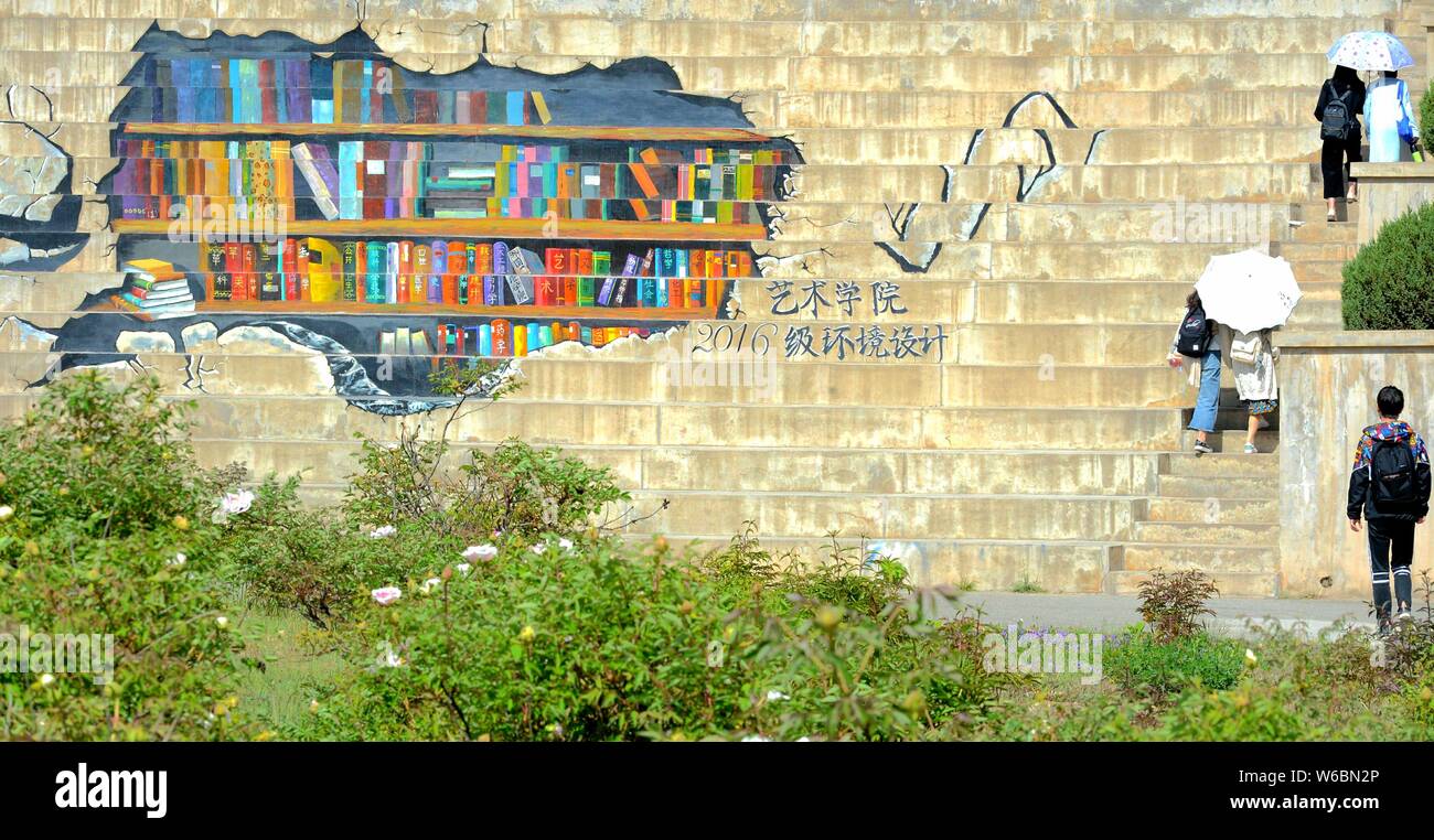 Students walk on a staircase with a 3D painting of a library at Lanzhou ...