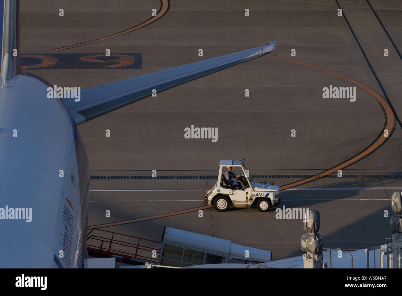 A ground crew member in an All Nippon Airways (ANA) vehicle drives ...