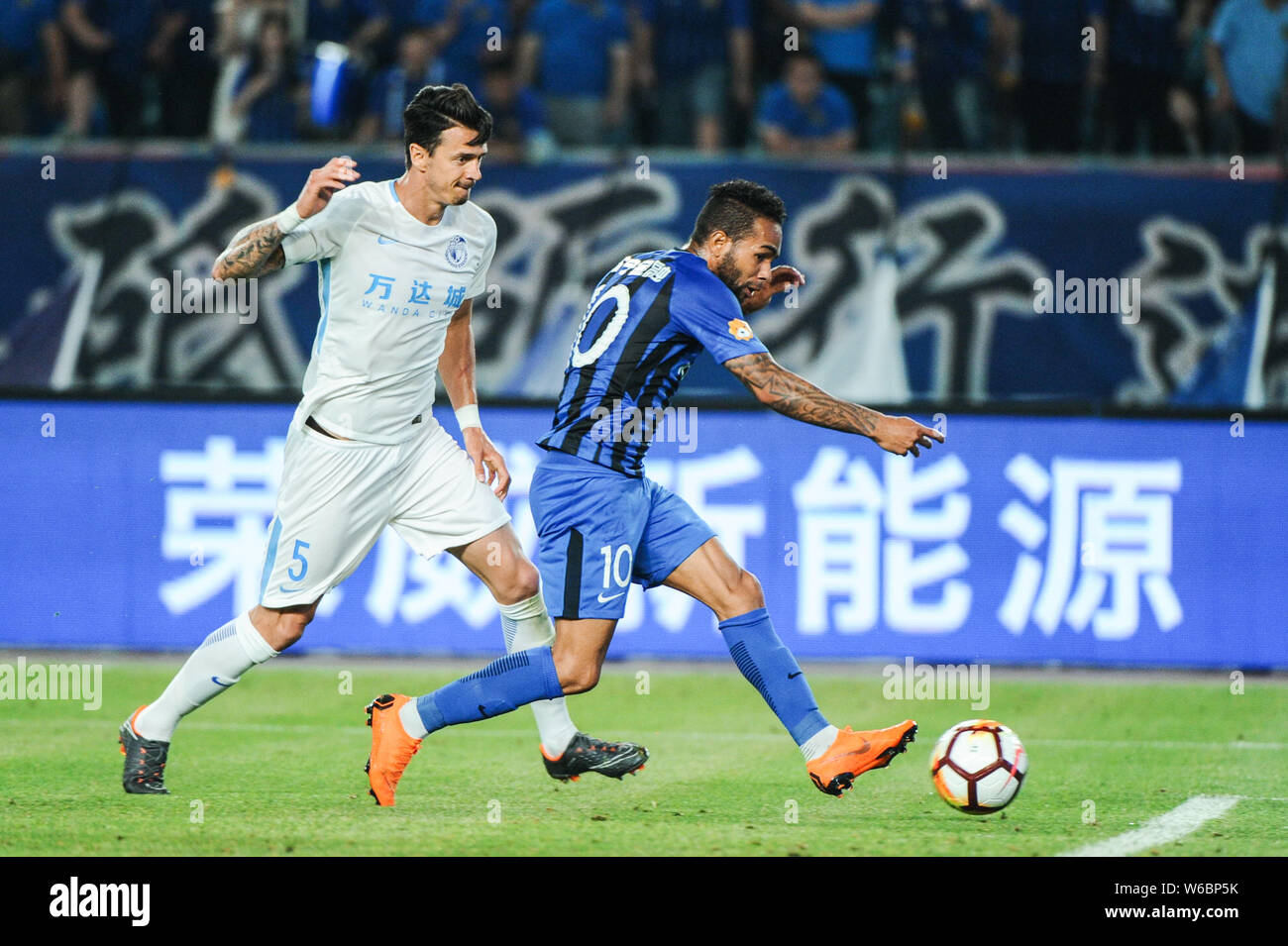 Brazilian football player Alex Teixeira, right, of Jiangsu Suning kicks ...