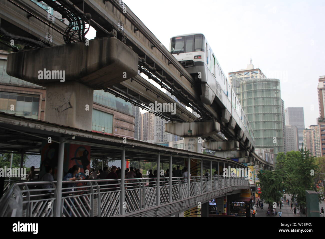 A monorail train of Chongqing Light Rail Line passes through a glass ...