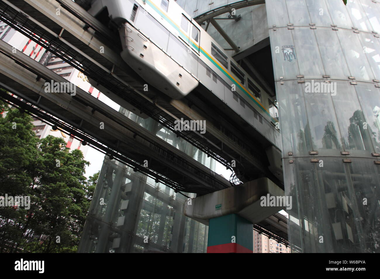 A monorail train of Chongqing Light Rail Line passes through a glass ...
