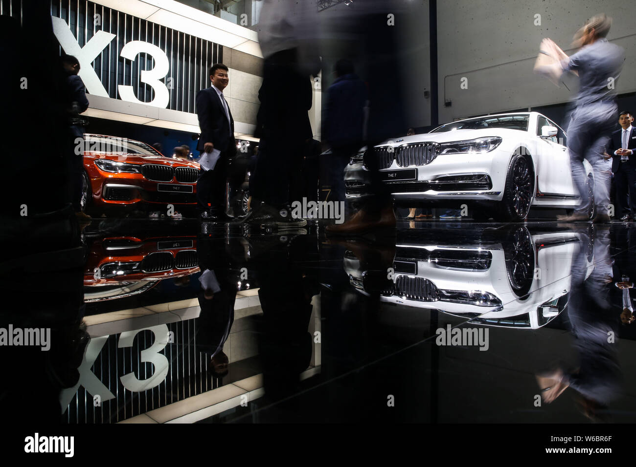 --FILE--Visitors look at a BMW X3 and other cars on display during the ...
