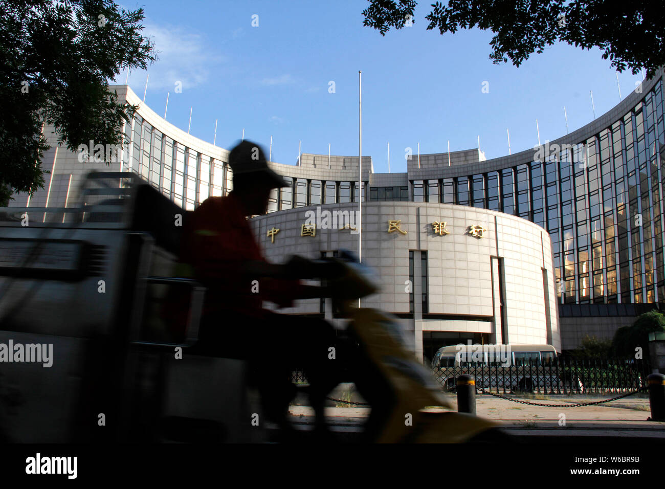 --FILE--A cyclist rides past the headquarters and head office of the ...