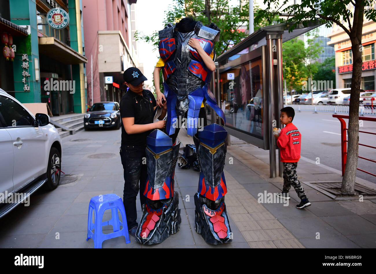 --FILE--25-year-old Chinese man Liu Sen tries out a realistic costume ...