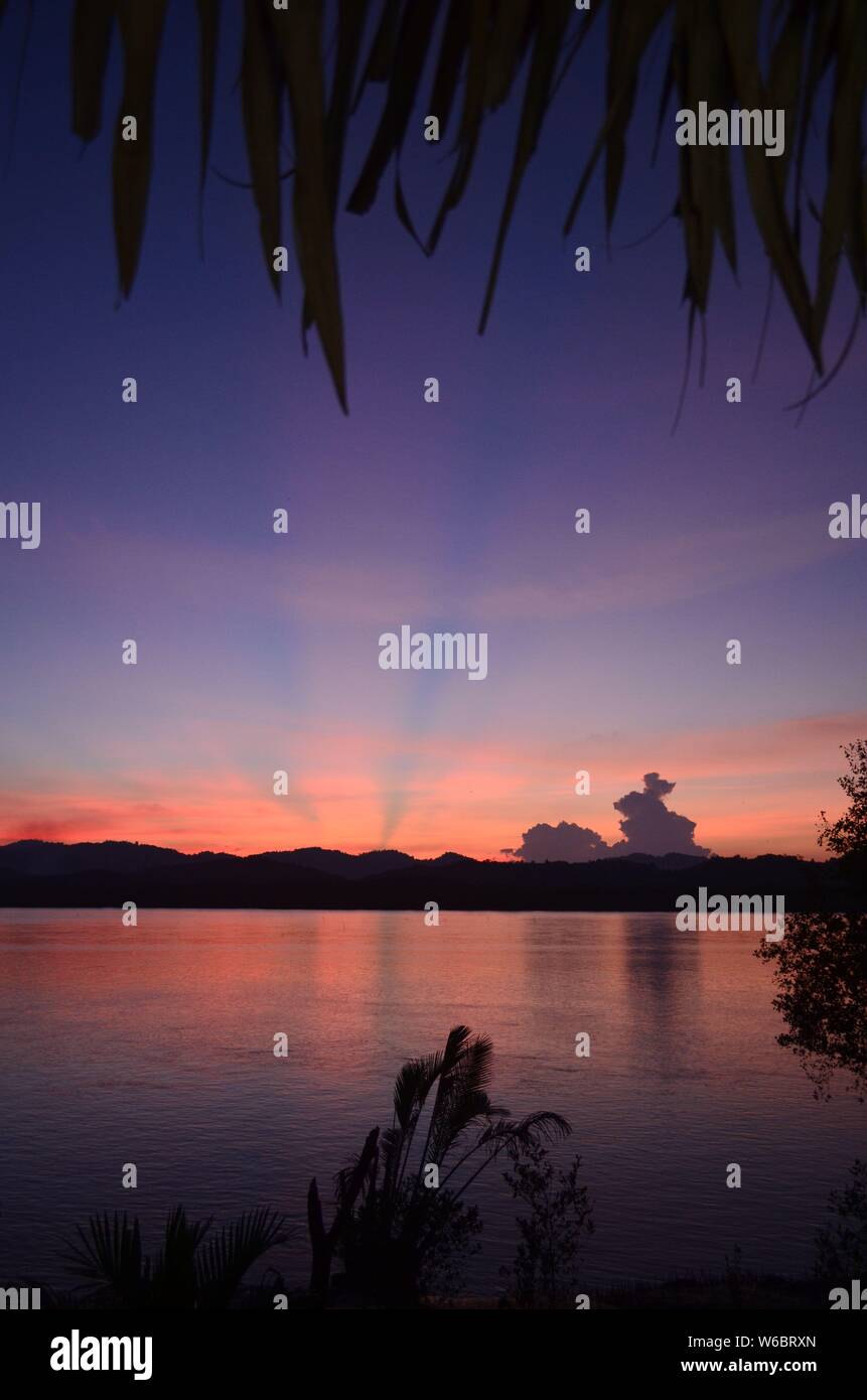 The sun setting over the Kra Buri river in Thailand overlooking the ...