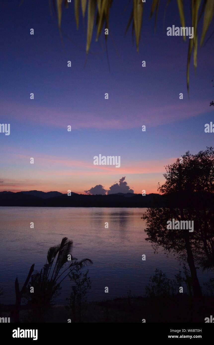 The sun setting over the Kra Buri river in Thailand overlooking the ...
