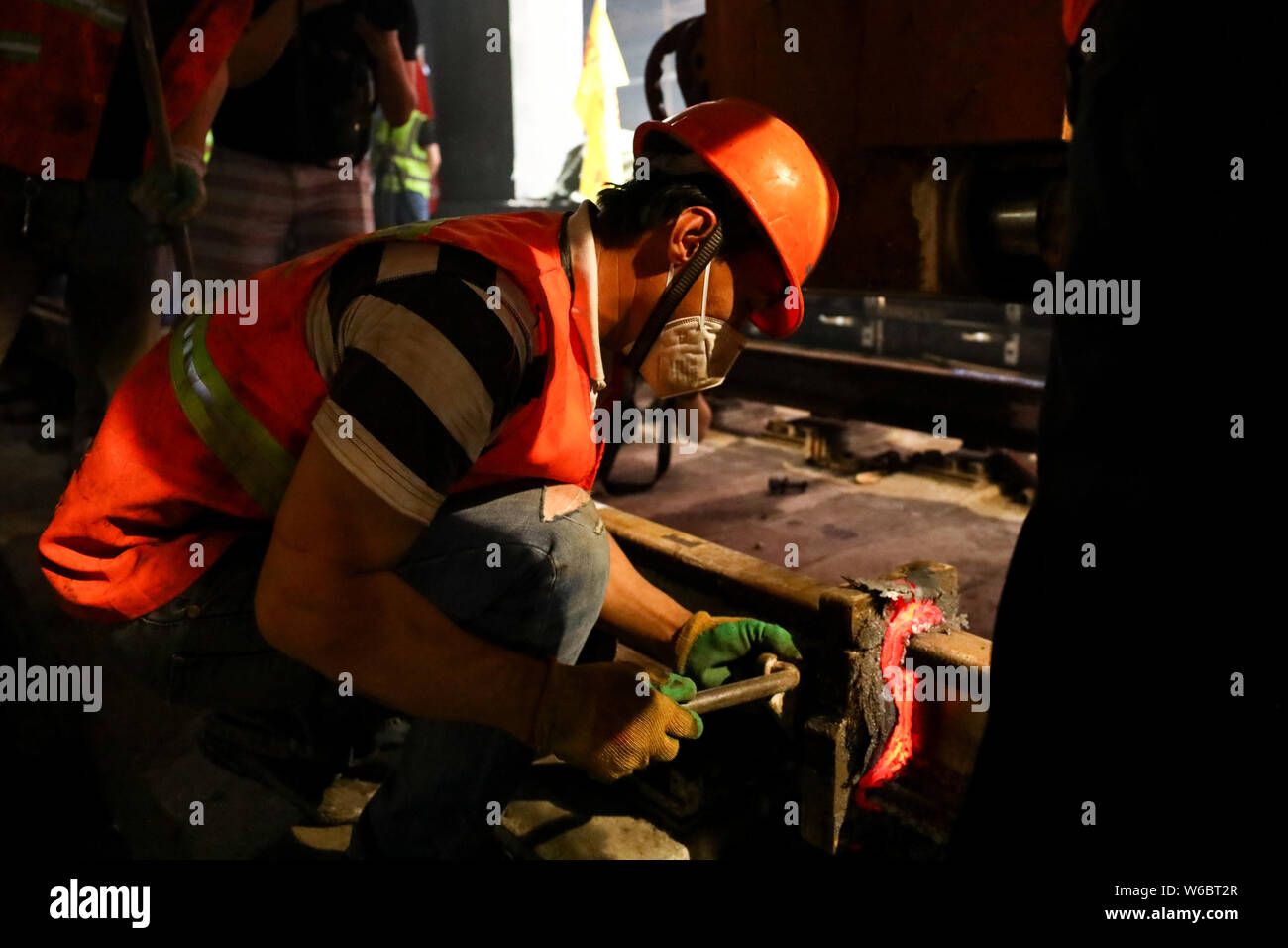 Chinese workers labor at the track construction site of the second and ...