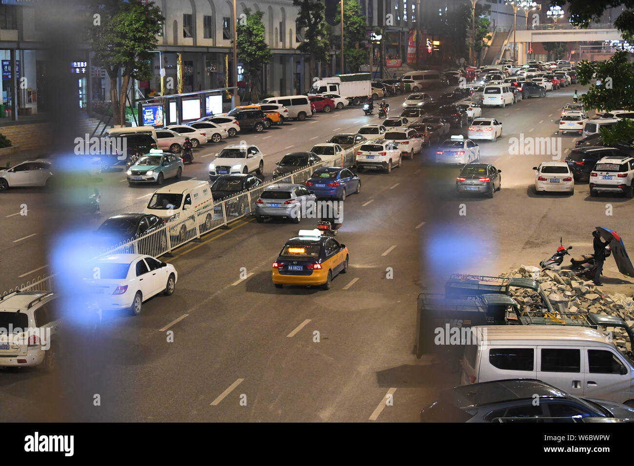 Vehicles are lined up on the innermost and outermost lanes of a two-way ...
