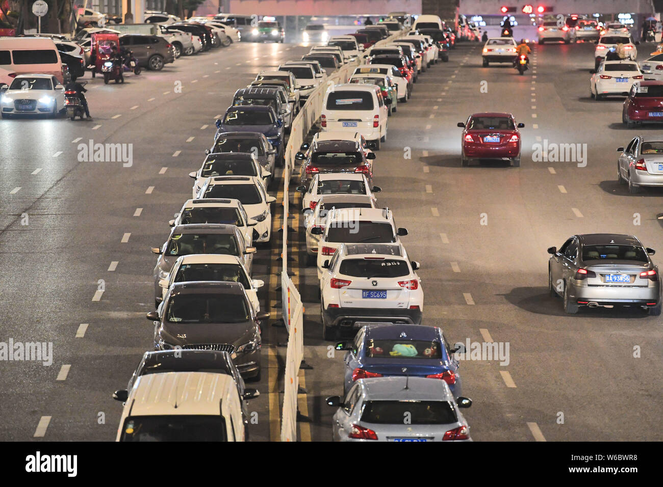 Vehicles are lined up on the innermost and outermost lanes of a two-way ...