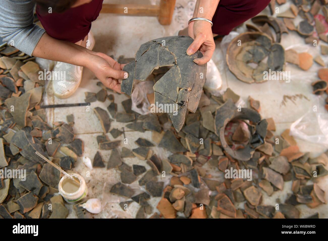 A Chinese archaeologist restores a ceramic ware unearthed from the ...