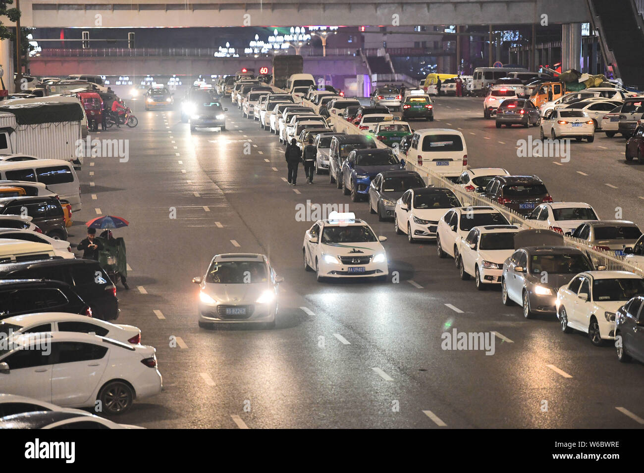 Vehicles are lined up on the innermost and outermost lanes of a two-way ...