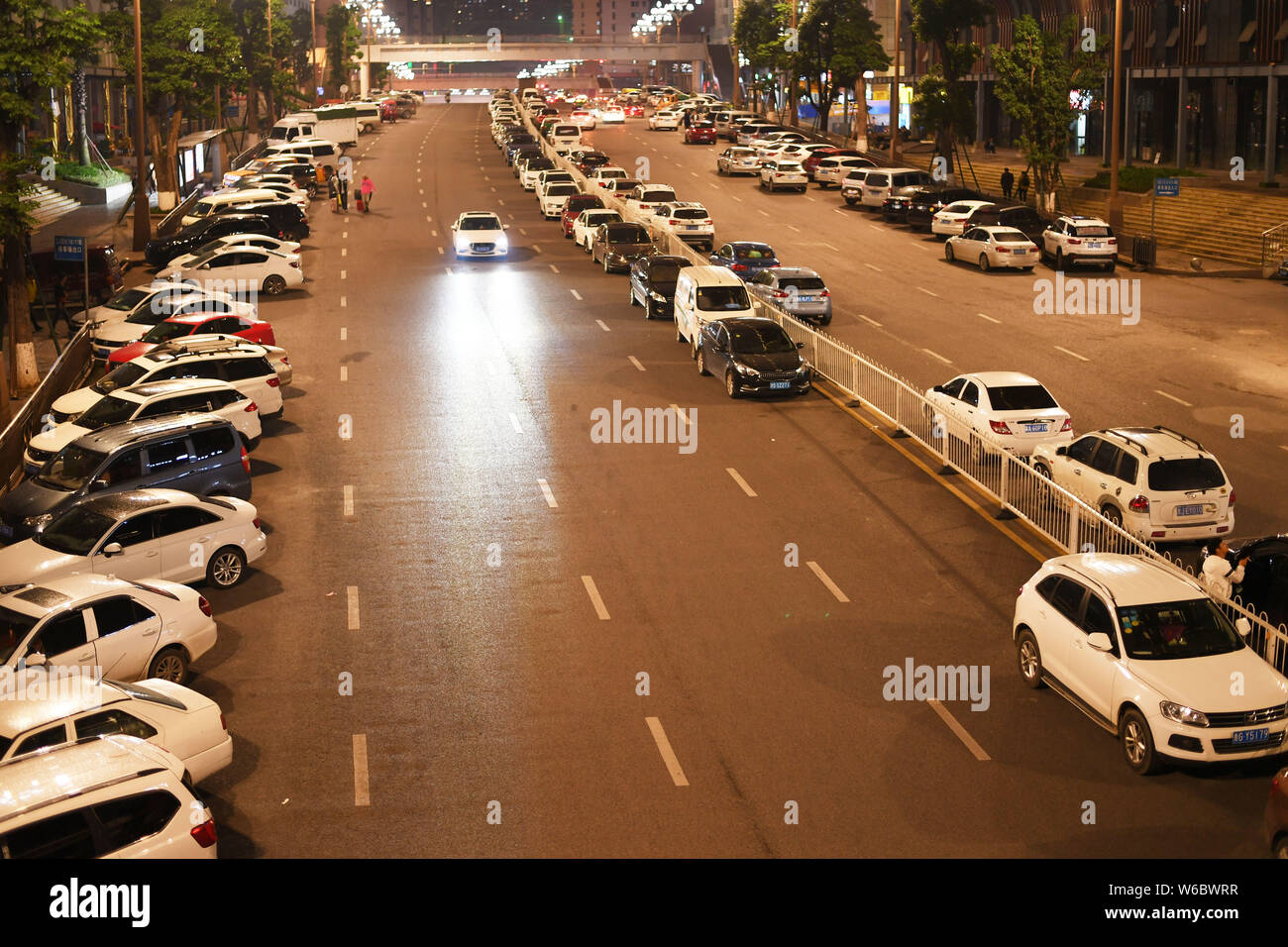 Vehicles are lined up on the innermost and outermost lanes of a two-way ...