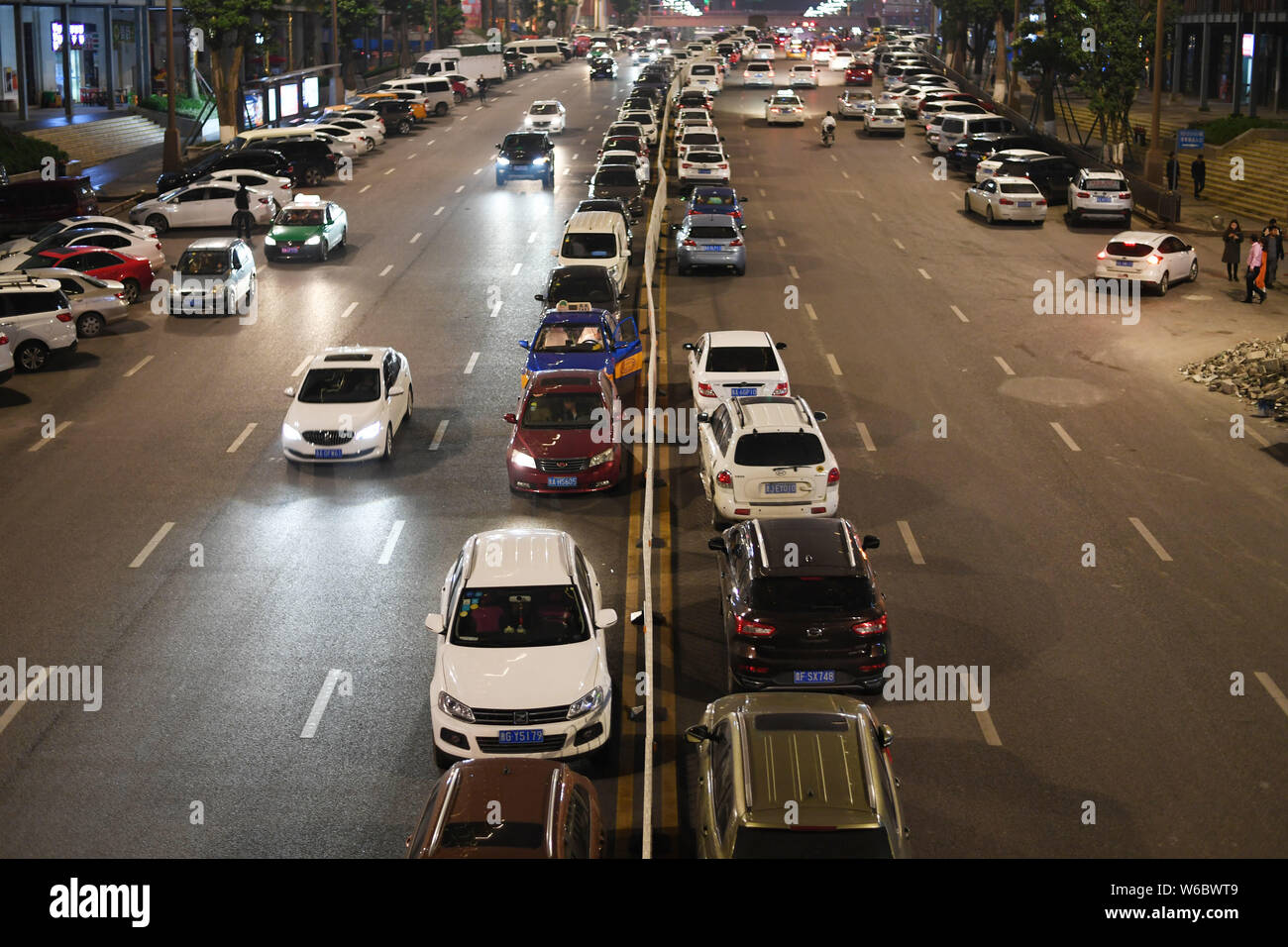 Vehicles are lined up on the innermost and outermost lanes of a two-way ...
