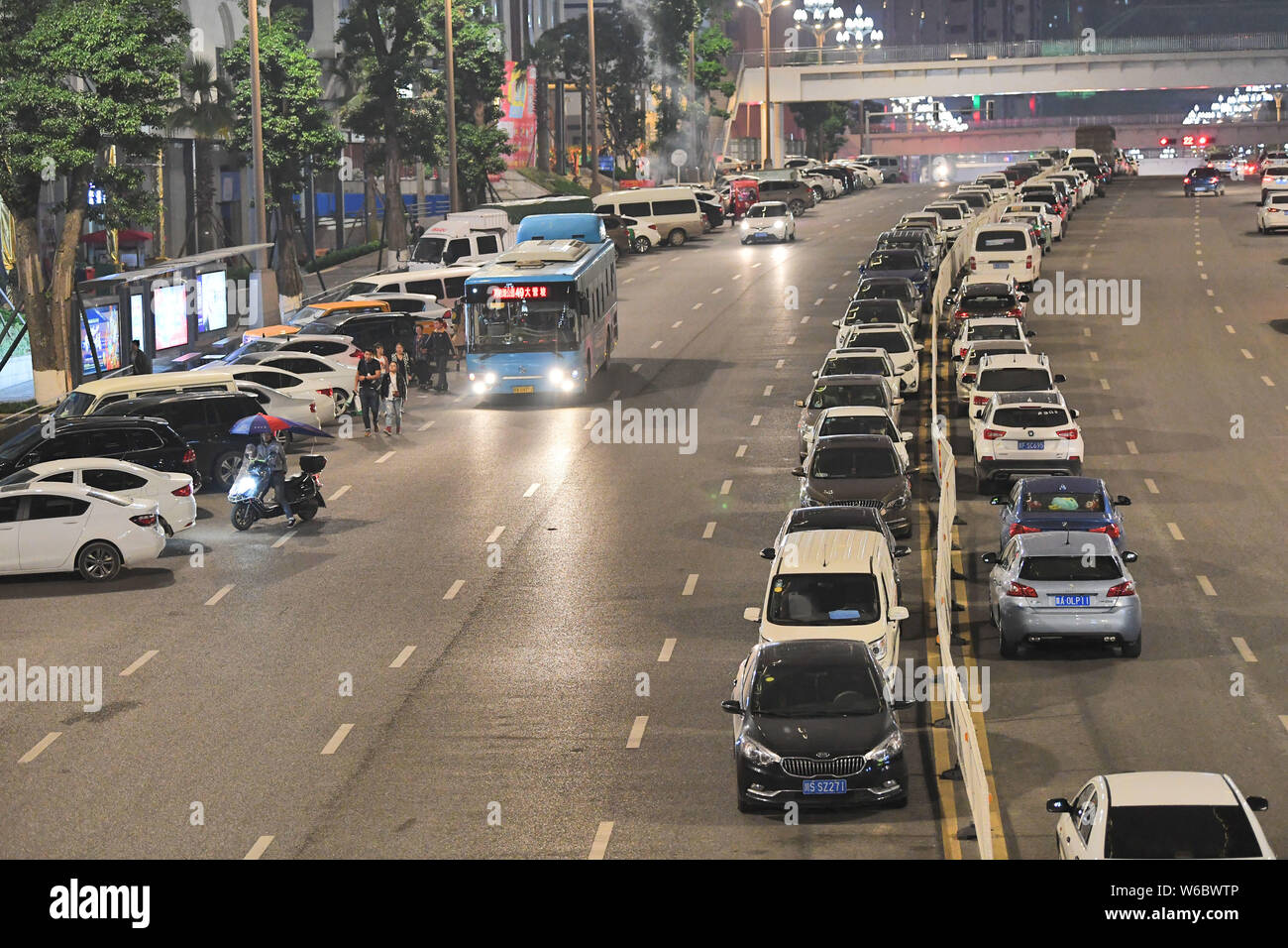 Vehicles are lined up on the innermost and outermost lanes of a two-way ...