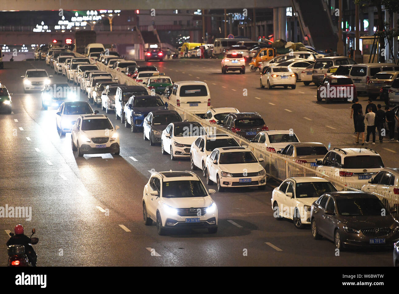 Vehicles are lined up on the innermost and outermost lanes of a two-way ...