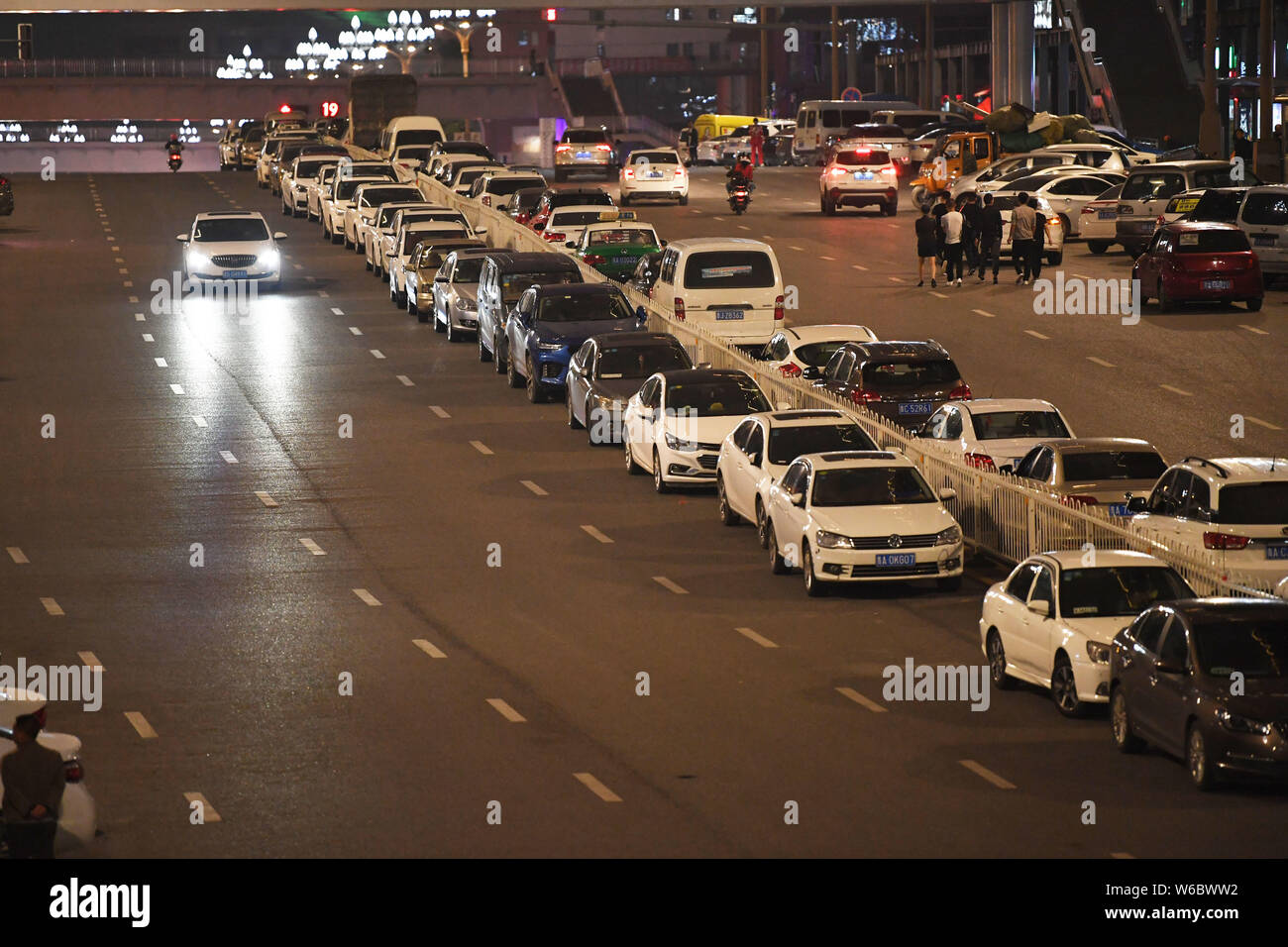 Vehicles are lined up on the innermost and outermost lanes of a two-way ...