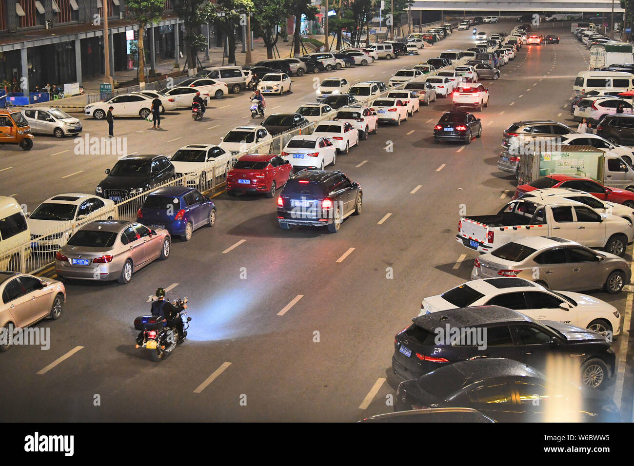 Vehicles are lined up on the innermost and outermost lanes of a two-way ...
