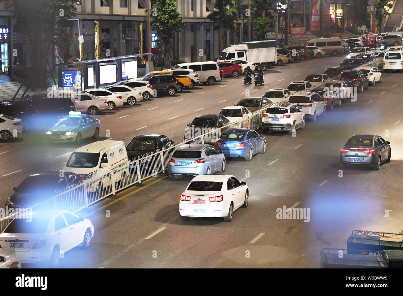 Vehicles are lined up on the innermost and outermost lanes of a two-way ...
