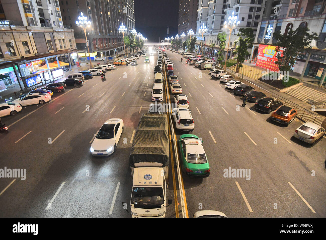 Vehicles are lined up on the innermost and outermost lanes of a two-way ...