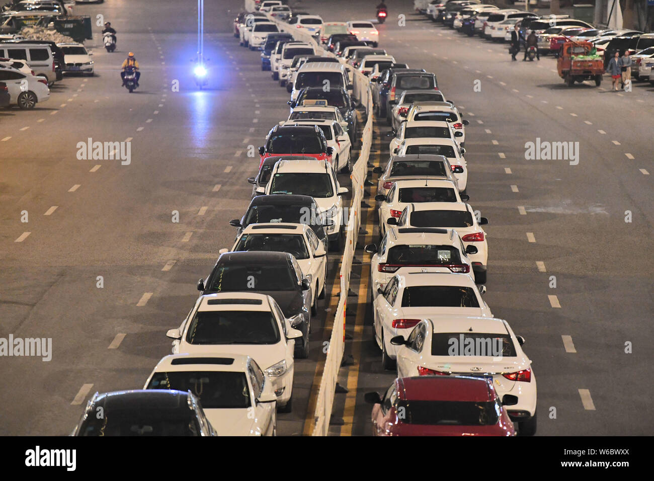 Vehicles are lined up on the innermost and outermost lanes of a two-way ...