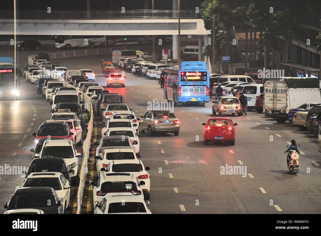 Vehicles are lined up on the innermost and outermost lanes of a two-way ...
