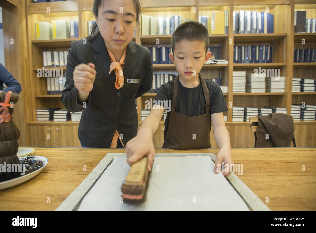A visitor experiences woodblock printing at the China Bookstore in ...