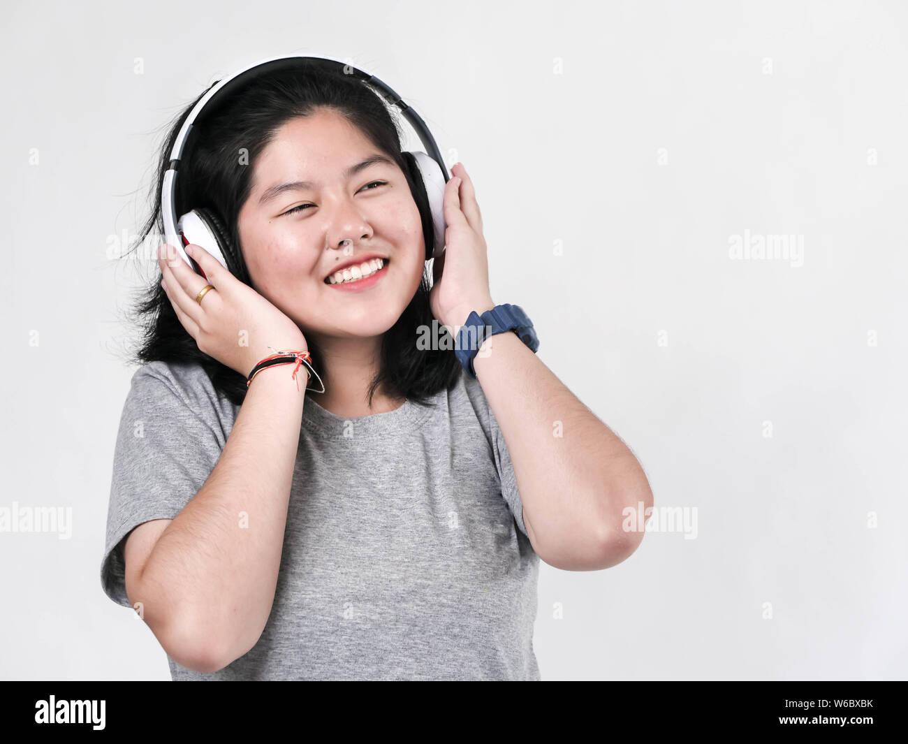 Happy Asian teenager girl using headphone and listening music Stock ...
