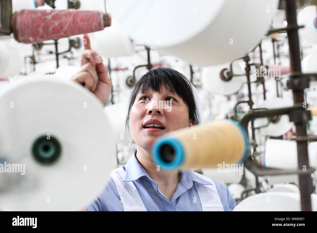 --FILE--A female Chinese worker handles production of yarn at a textile factory in Nanping city ...