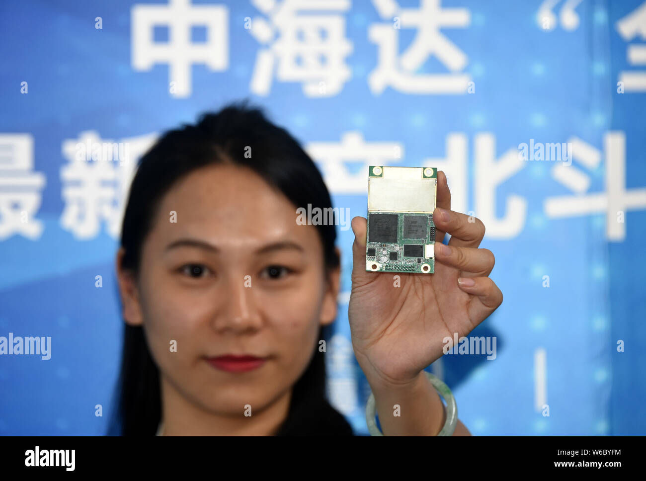 An employee displays the radio frequency chip Hengxing-1 of Hi-Target ...